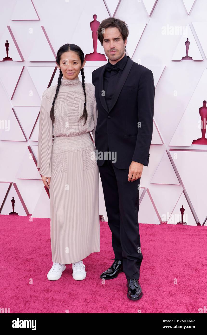 Chloe Zhao, left, and Joshua James Richards arrive at the Oscars on Sunday, April 25, 2021, at ...