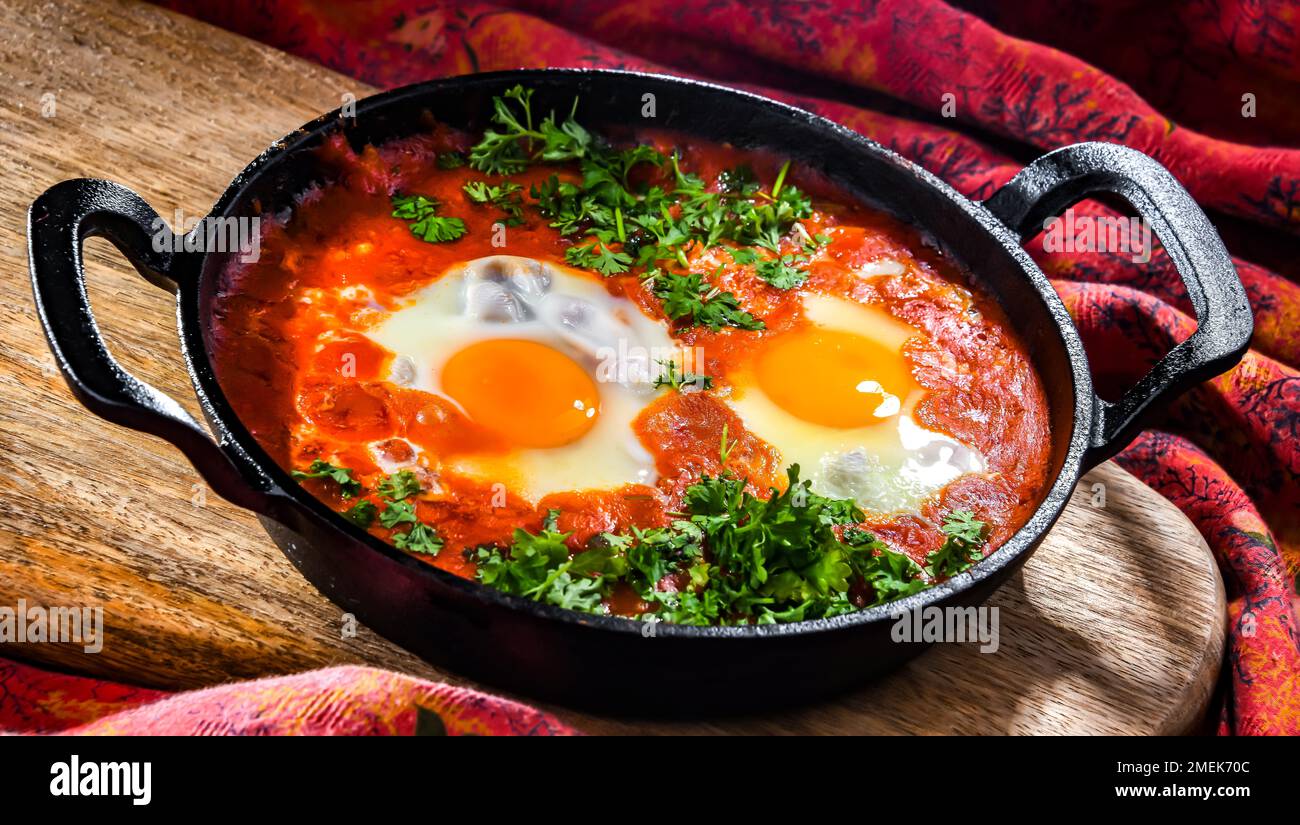 Shakshouka dish in a cast iron pan Stock Photo - Alamy