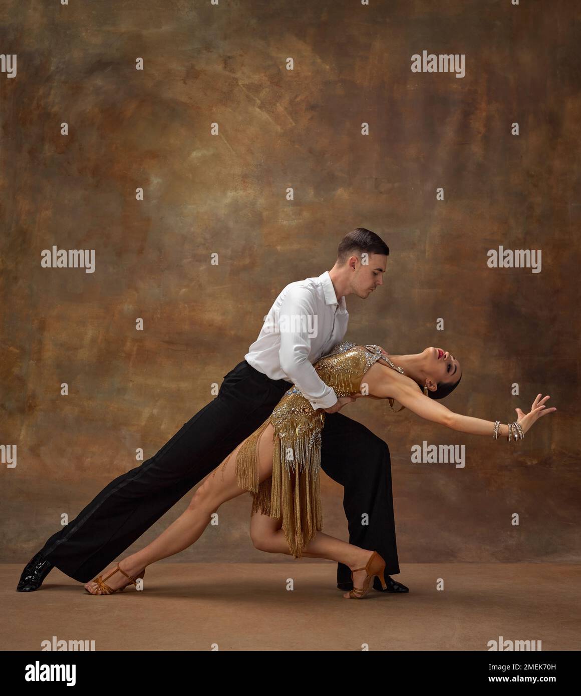 Man and woman, professional tango dancers in stylish, beautiful stage costumes performing over ...