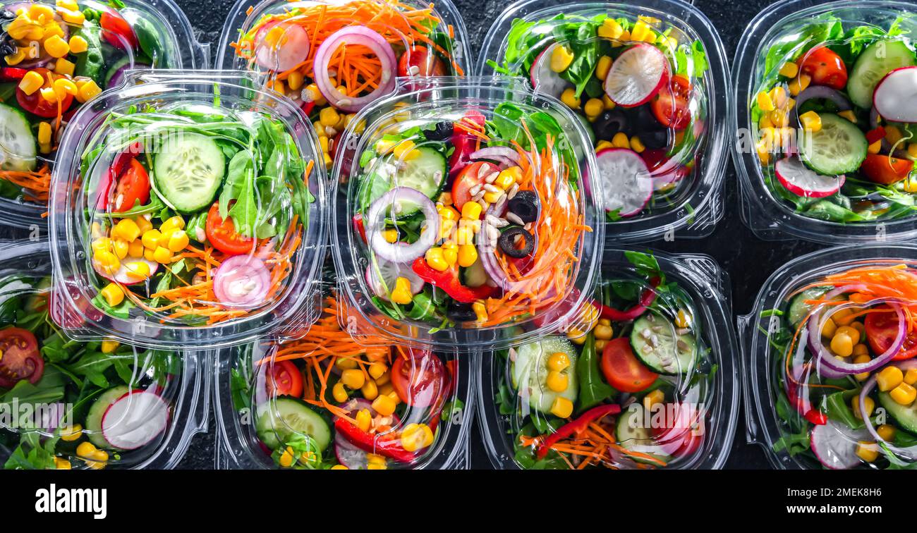 Plastic boxes with pre-packaged vegetable salads, put up for sale in a ...