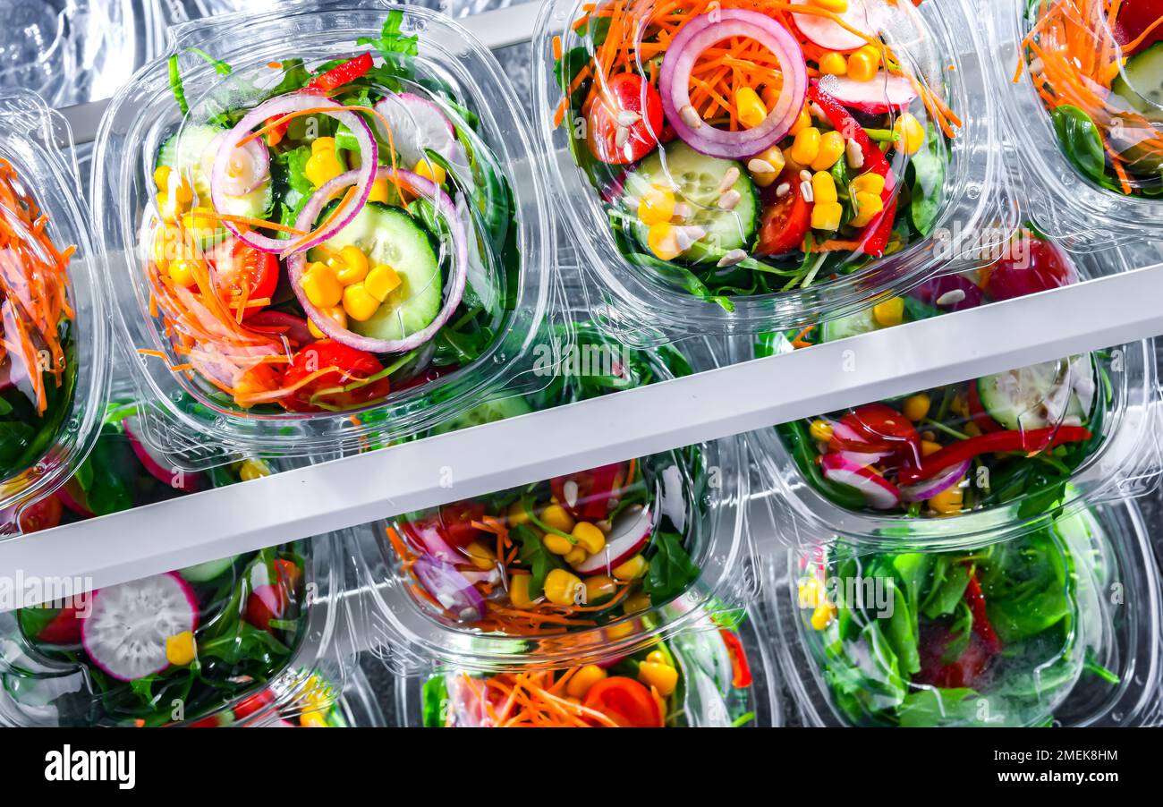 Plastic boxes with pre-packaged vegetable salads, put up for sale in a ...