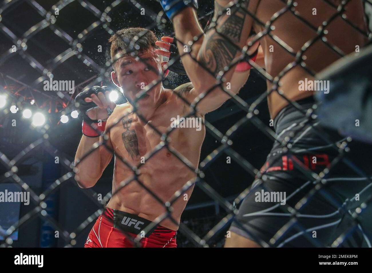 Aoriqileng faces Jeffrey Molina, right, at the octagon fence during a ...