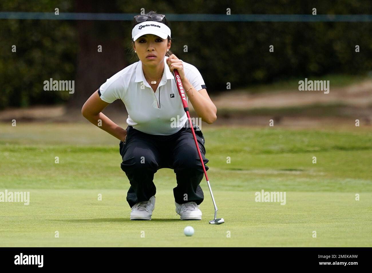 Muni He lines up a shot on the first green during the final round of ...