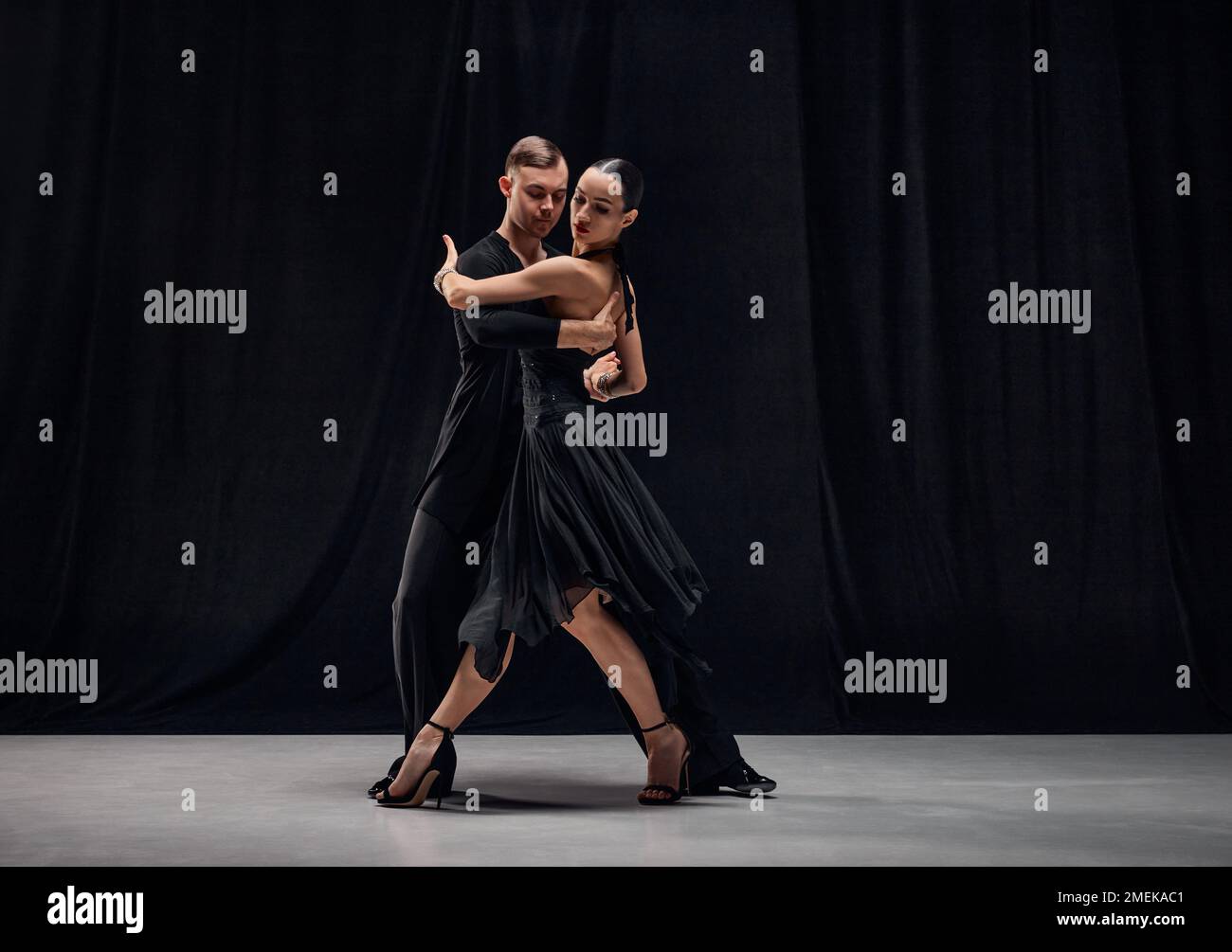 Style, passion, romance. Man and woman, professional tango dancers performing in black stage ...