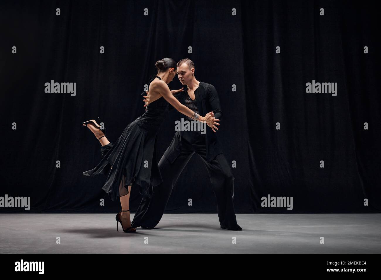 Man and woman, professional tango dancers performing in black stage ...