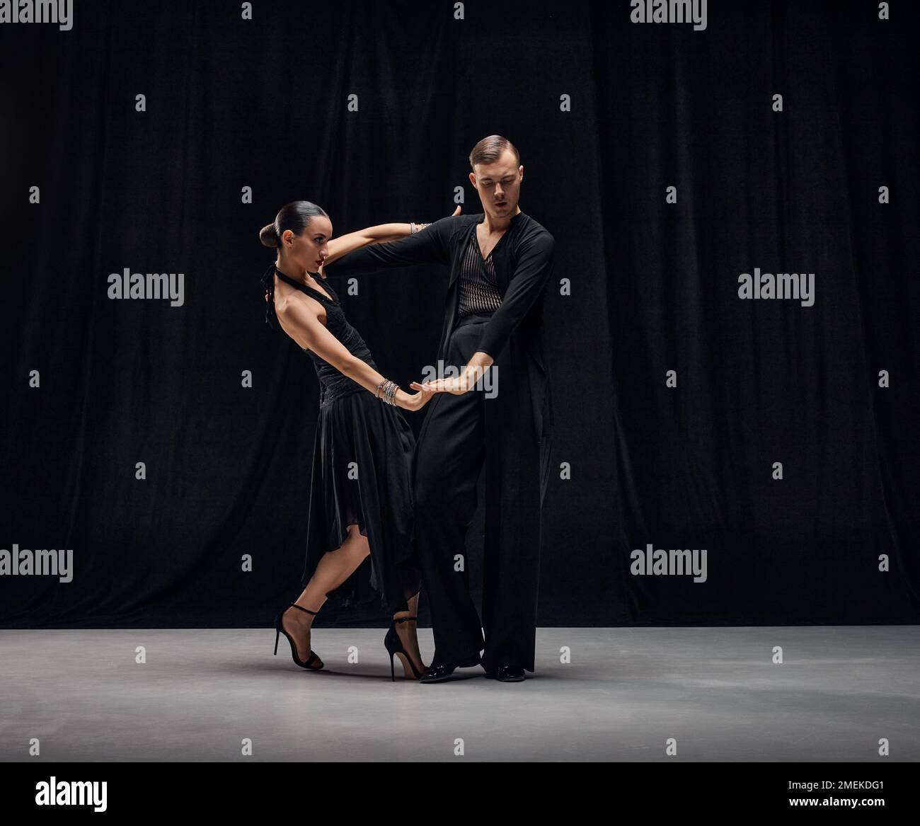 Man and woman, professional tango dancers performing in black stage ...
