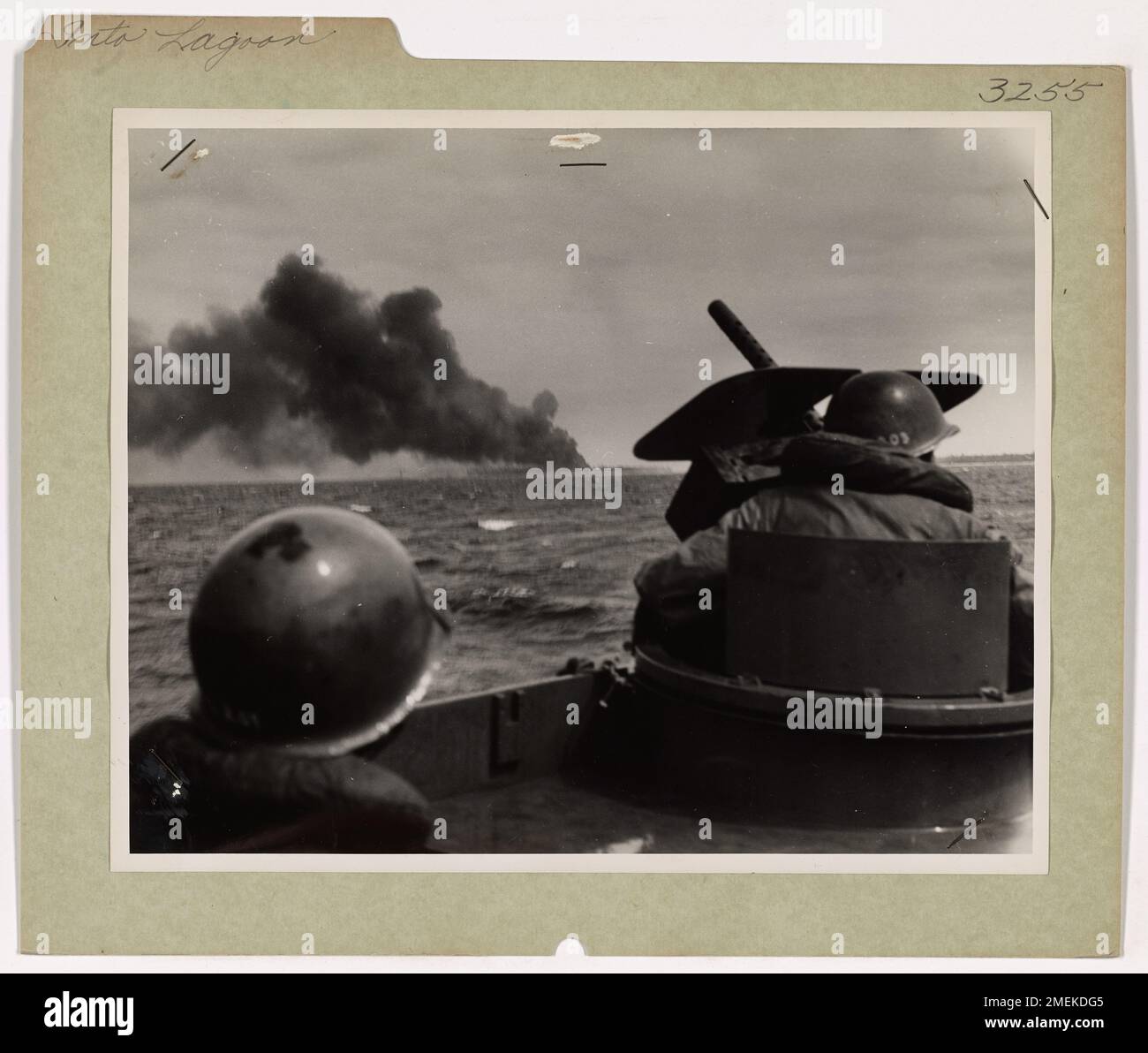 A Coast Guard gunner stands ready as the crew of a Coast Guard-manned ...