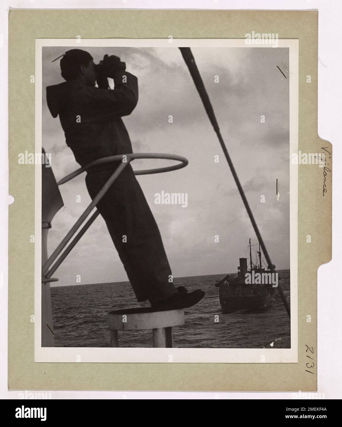 A Coast Guardsman keeps watch through binoculars aboard a Coast Guard ...
