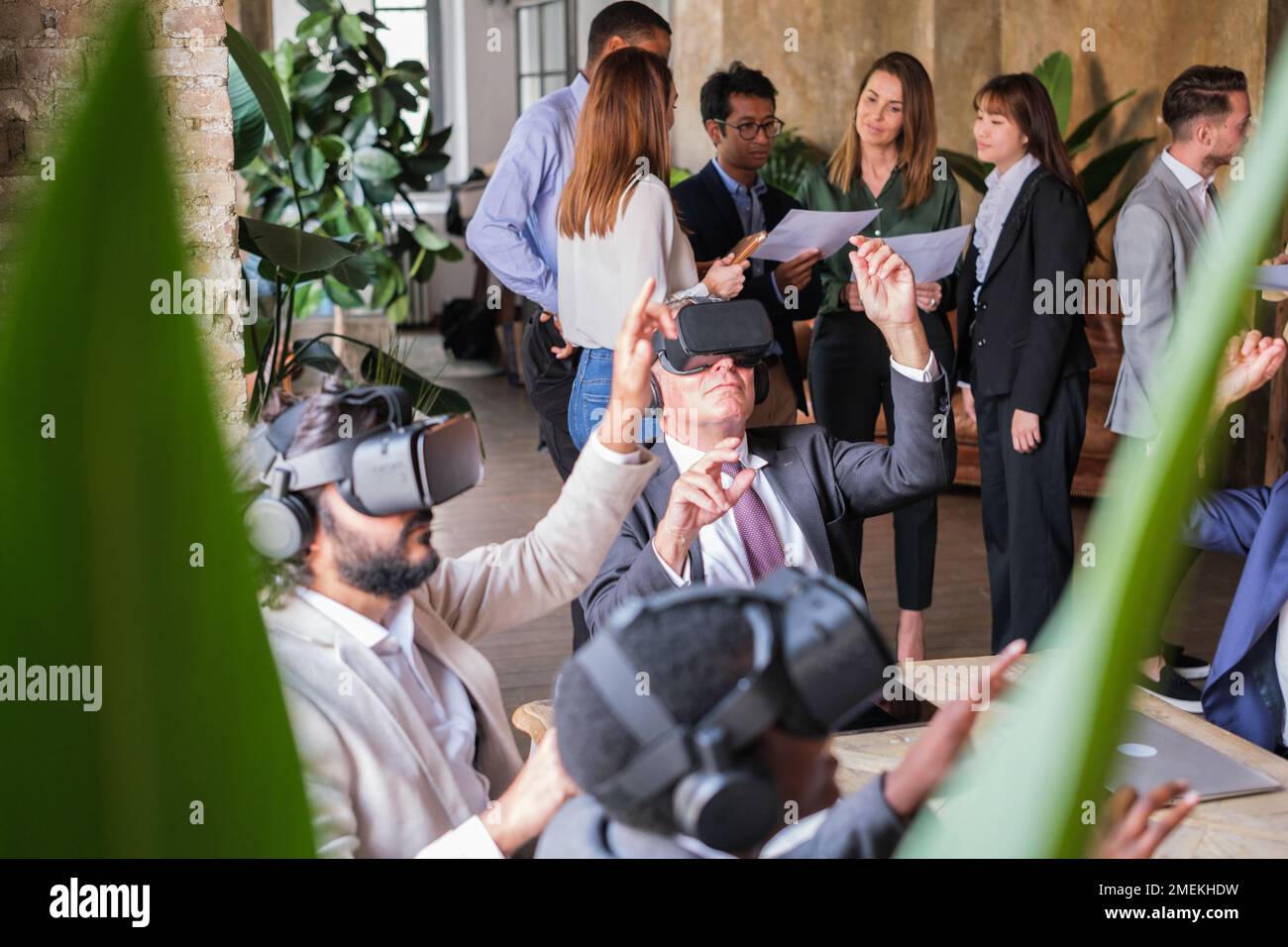 Group of business people doing virtual reality activities while other ...