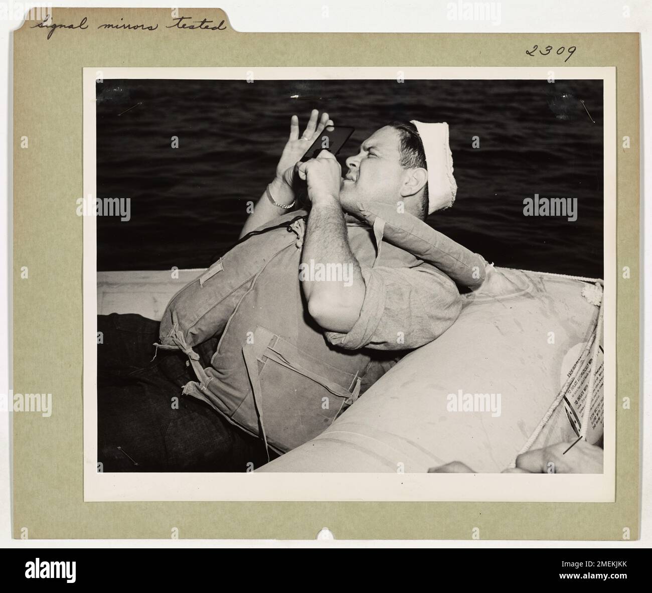 Coast Guardsman Philip Jacobs demonstrates the use of signal mirrors ...