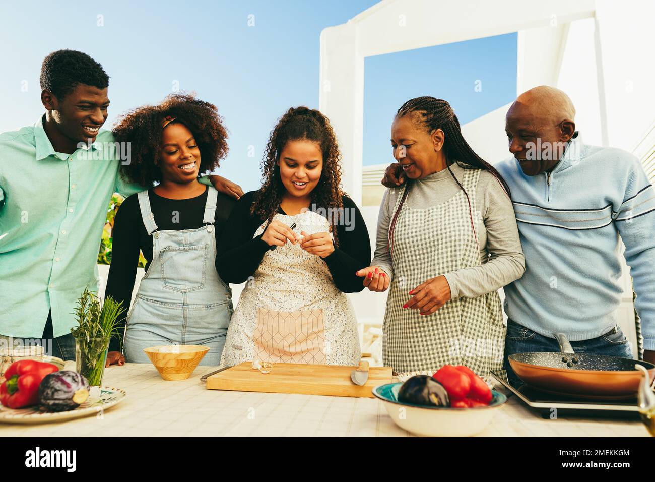 Happy african family cooking together in outdoor kitchen at home ...