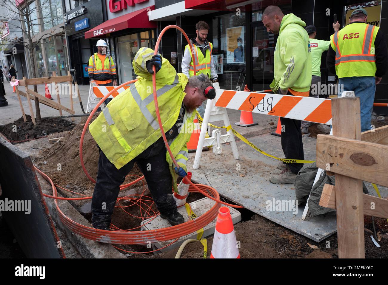 Workers install conduit that will hold Verizon's fiber-optic cable ...