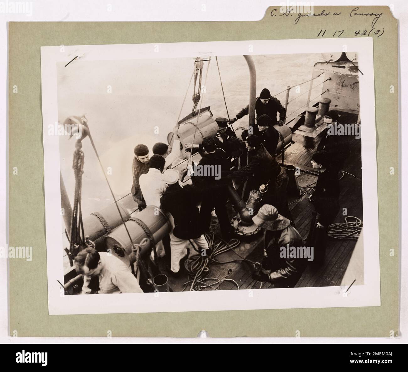 Coast Guardsmen prepare depth charges as they guard a convoy, ensuring ...
