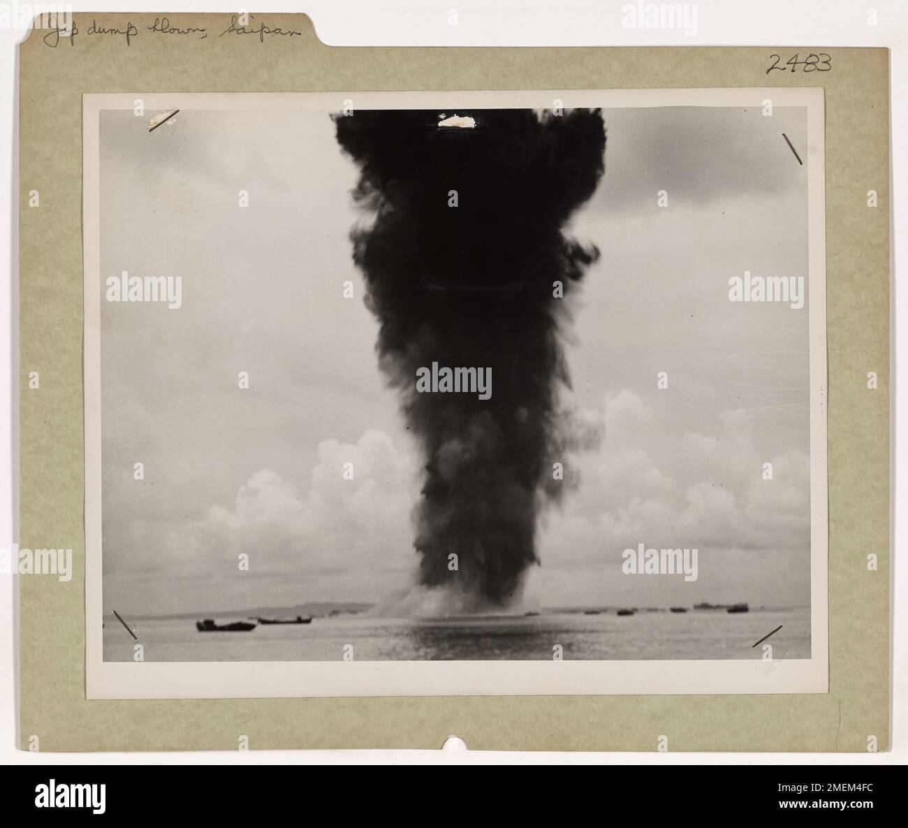 A dramatic photograph captures a column of black smoke rising from a ...