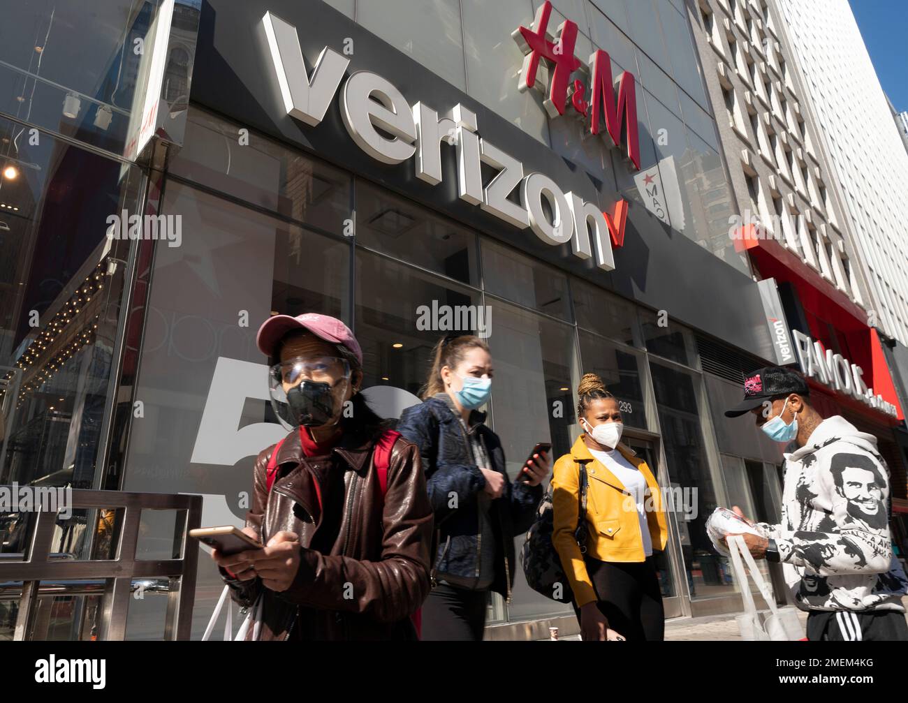 People use mobile phones outside a Verizon store, Monday, April 19 ...