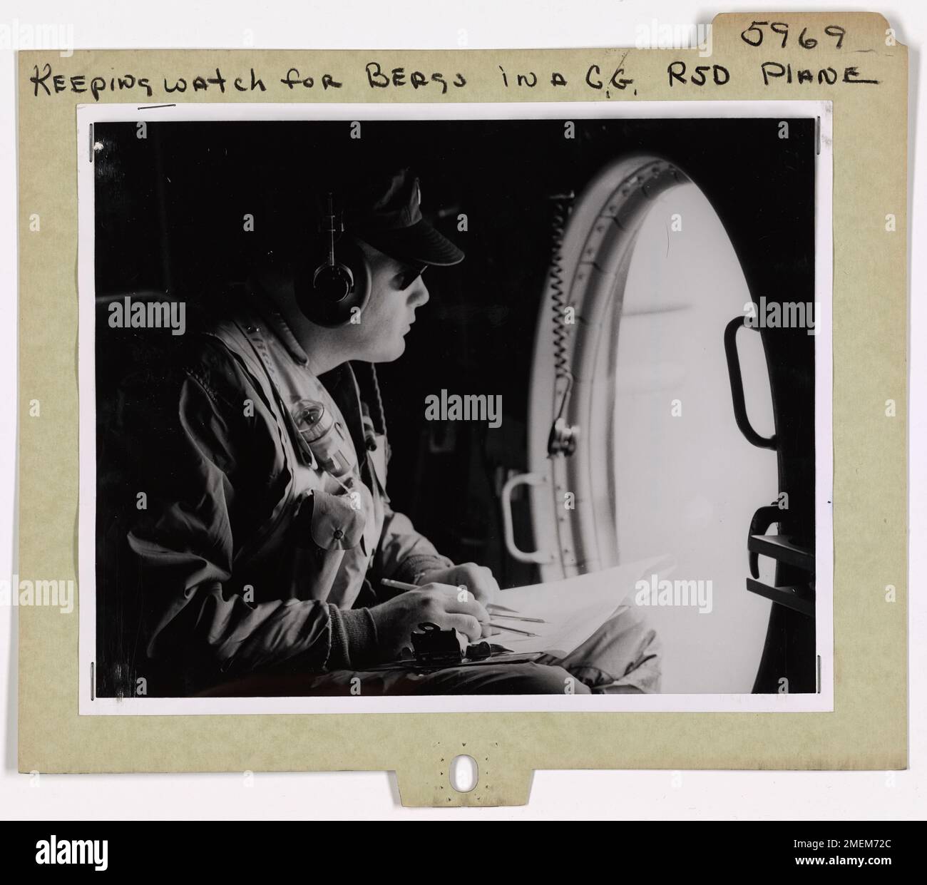 Ice Observer. An observer keeps watch for icebergs at the window of a ...