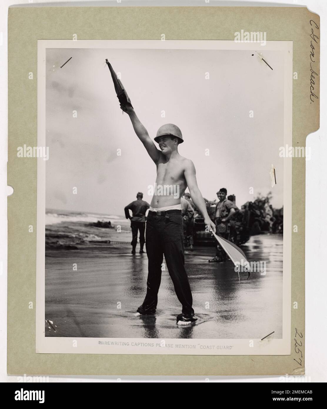 This image shows a Coast Guardsman using semaphore flags to direct ...