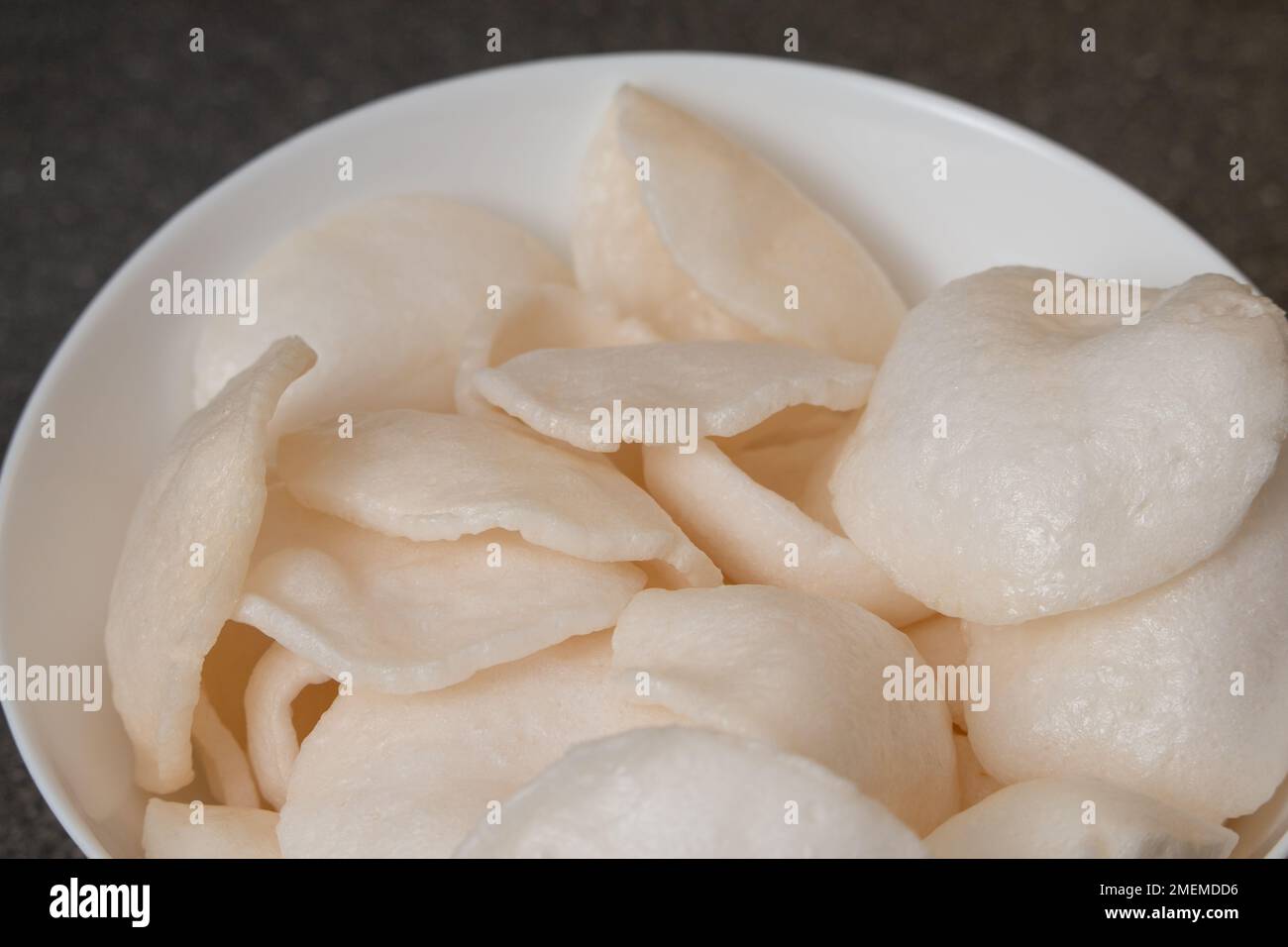 Cooked rice chips in bowl - Grey background Stock Photo - Alamy