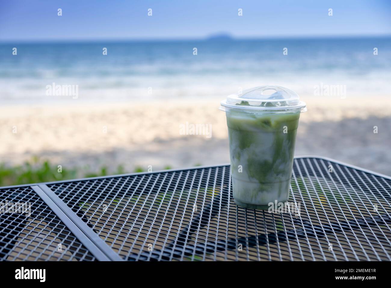 Iced green tea matcha with beach background Stock Photo - Alamy