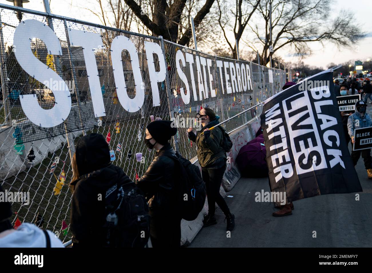 A sign reading "Stop state terror" is hung on a perimeter security ...