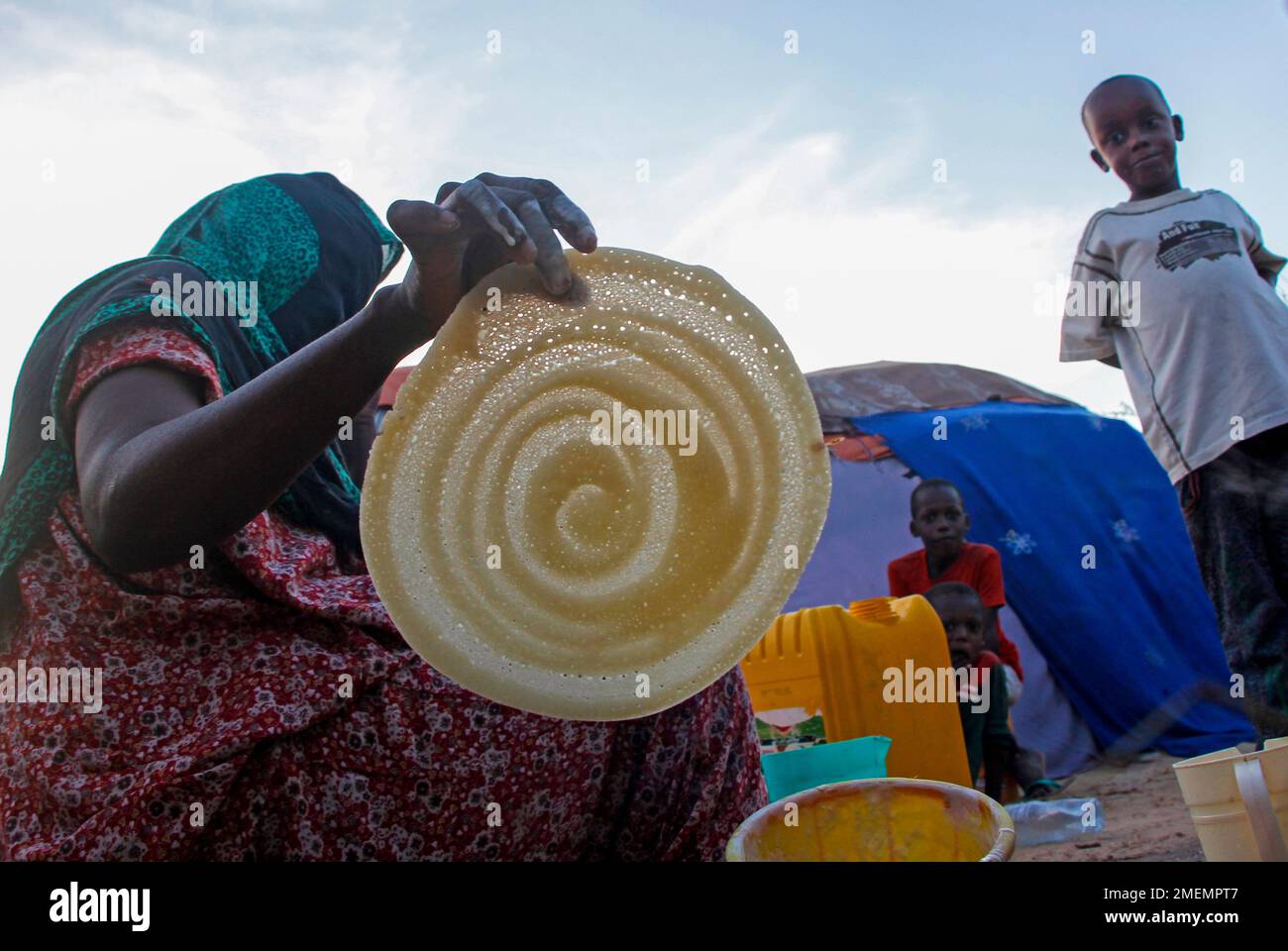 A Somali woman makes pancakes for her family to break their dawn-to ...