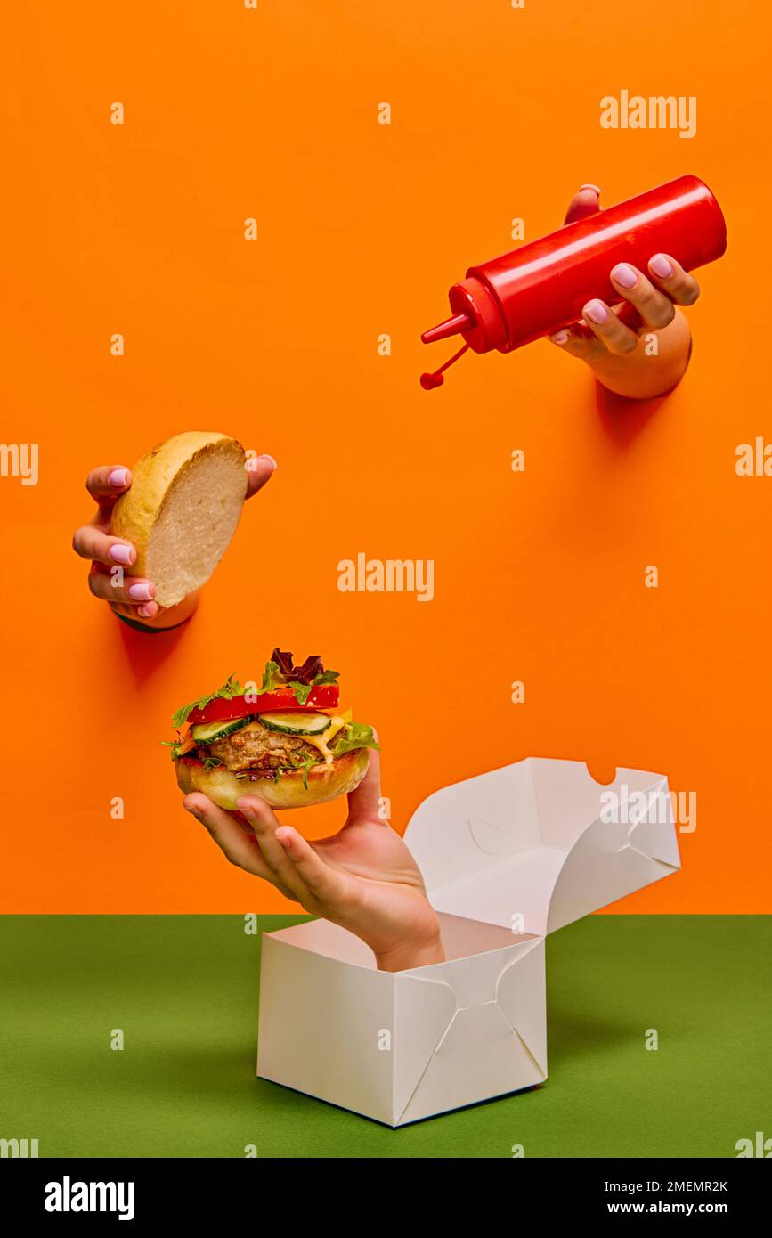 Food pop art photography. Female hand sticking out orange paper with ...
