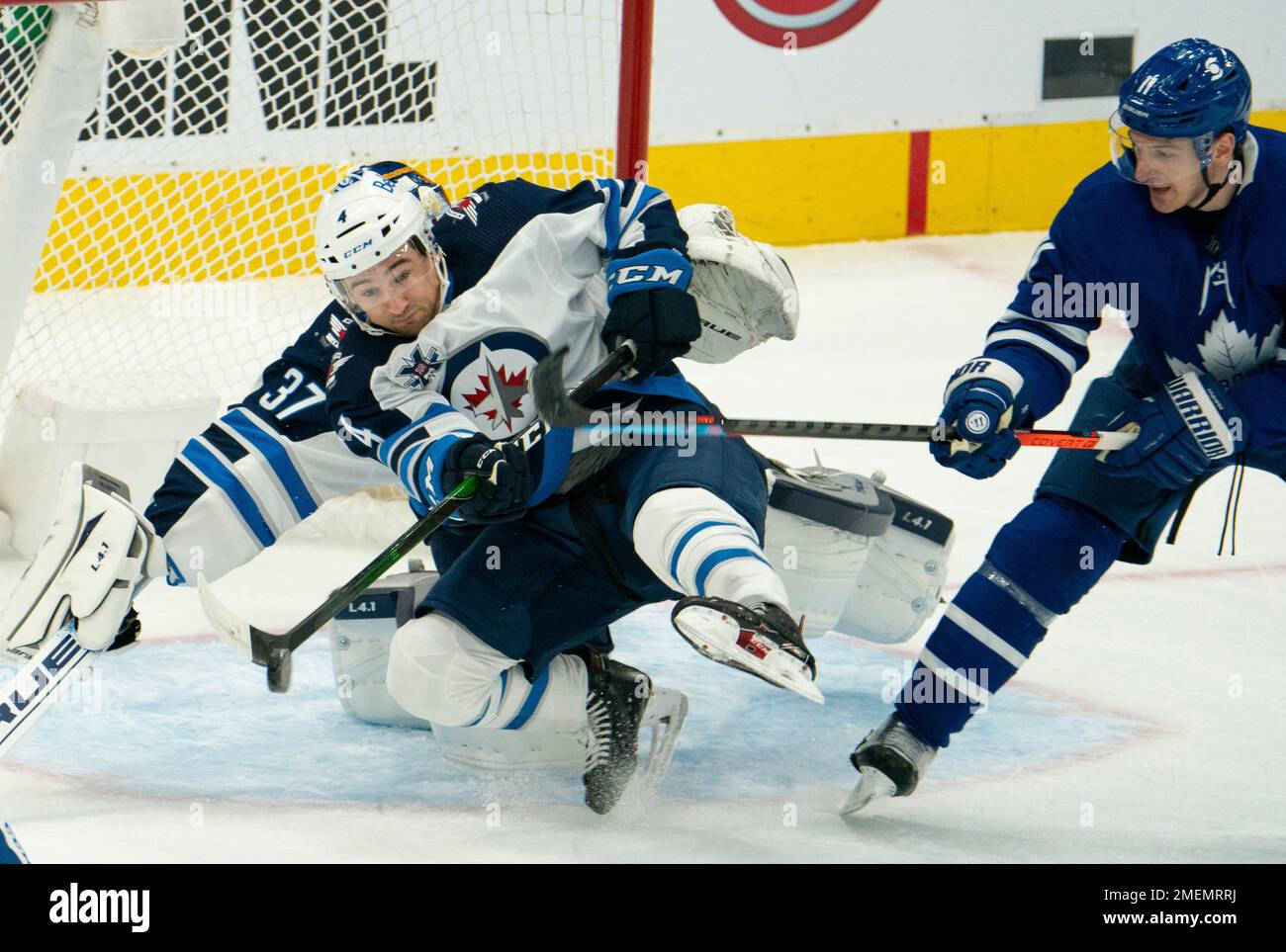 Winnipeg Jets defenceman Neal Pionk(4) clears the puck while being ...