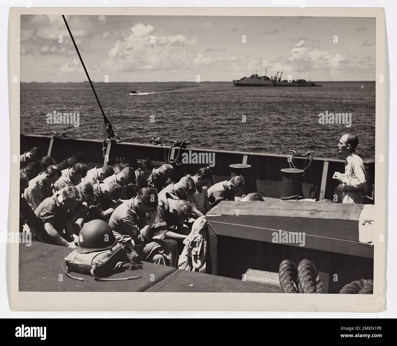 U.S. Coast Guardsmen and Marines bow their heads in prayer for the ...