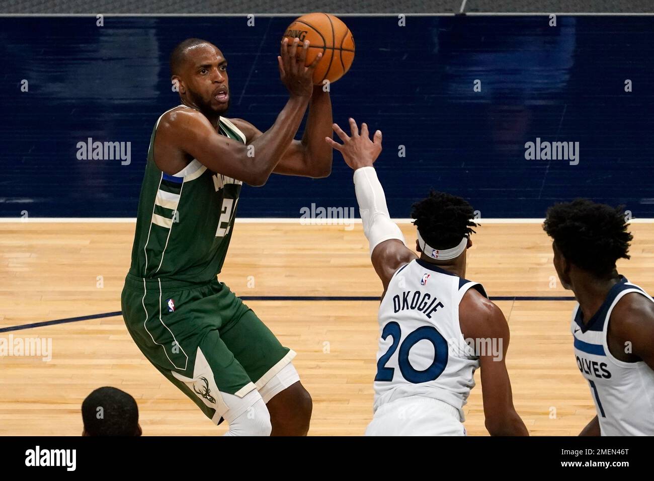 Milwaukee Bucks' Khris Middleton, left, eyes the basket as Minnesota ...