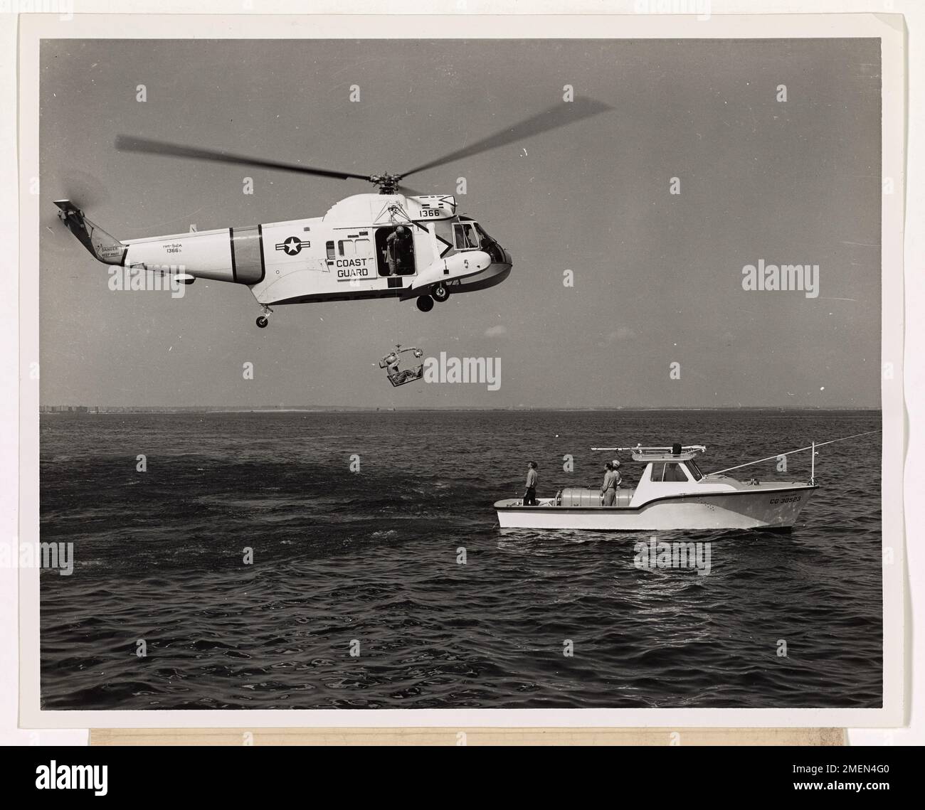 This image shows a Coast Guard helicopter preparing to transfer an ...