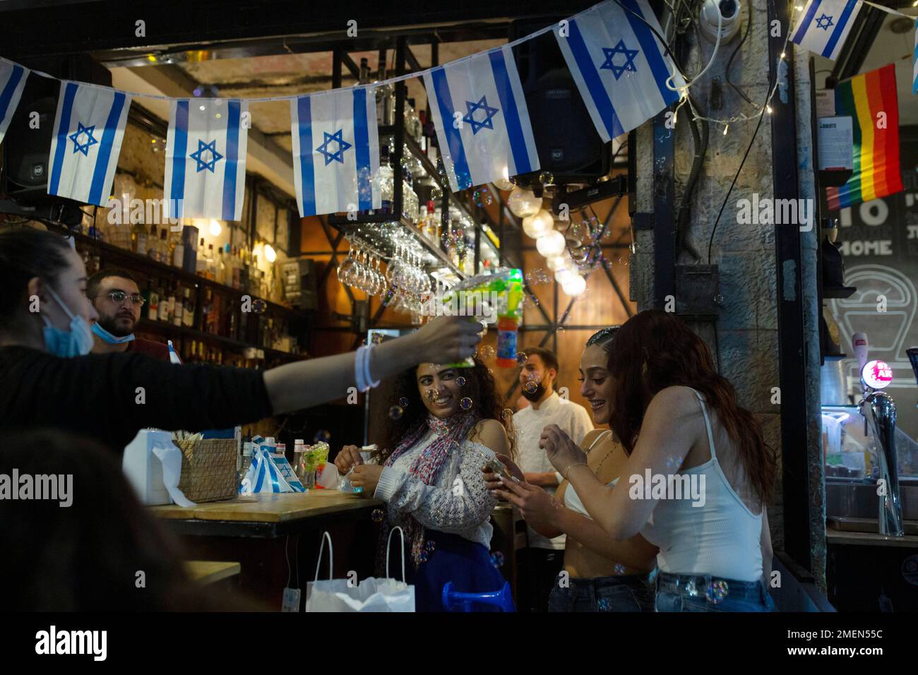 Israeli women check a selfie they took at a bar as they celebrate ...