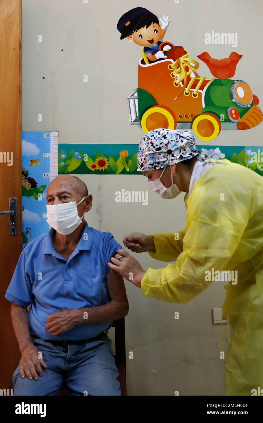 A man gets a shot of India's COVAXIN vaccine for COVID-19 in the public ...