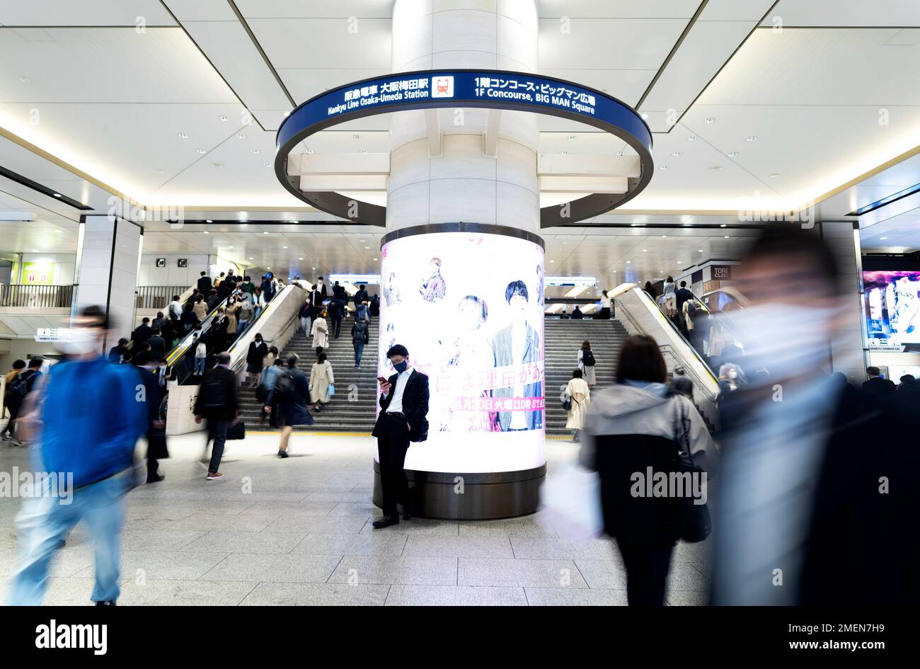 People wearing face masks walk near a train station in Osaka, western ...