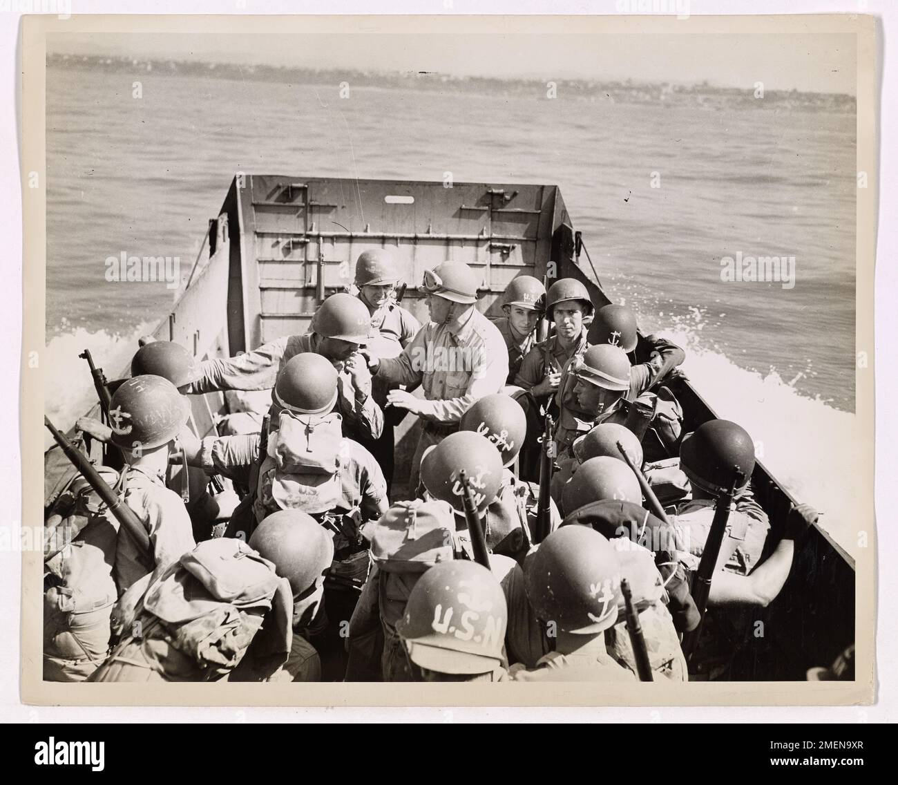 U.S. Coast Guardsmen navigate a boat to a Sicilian beach to set up a ...