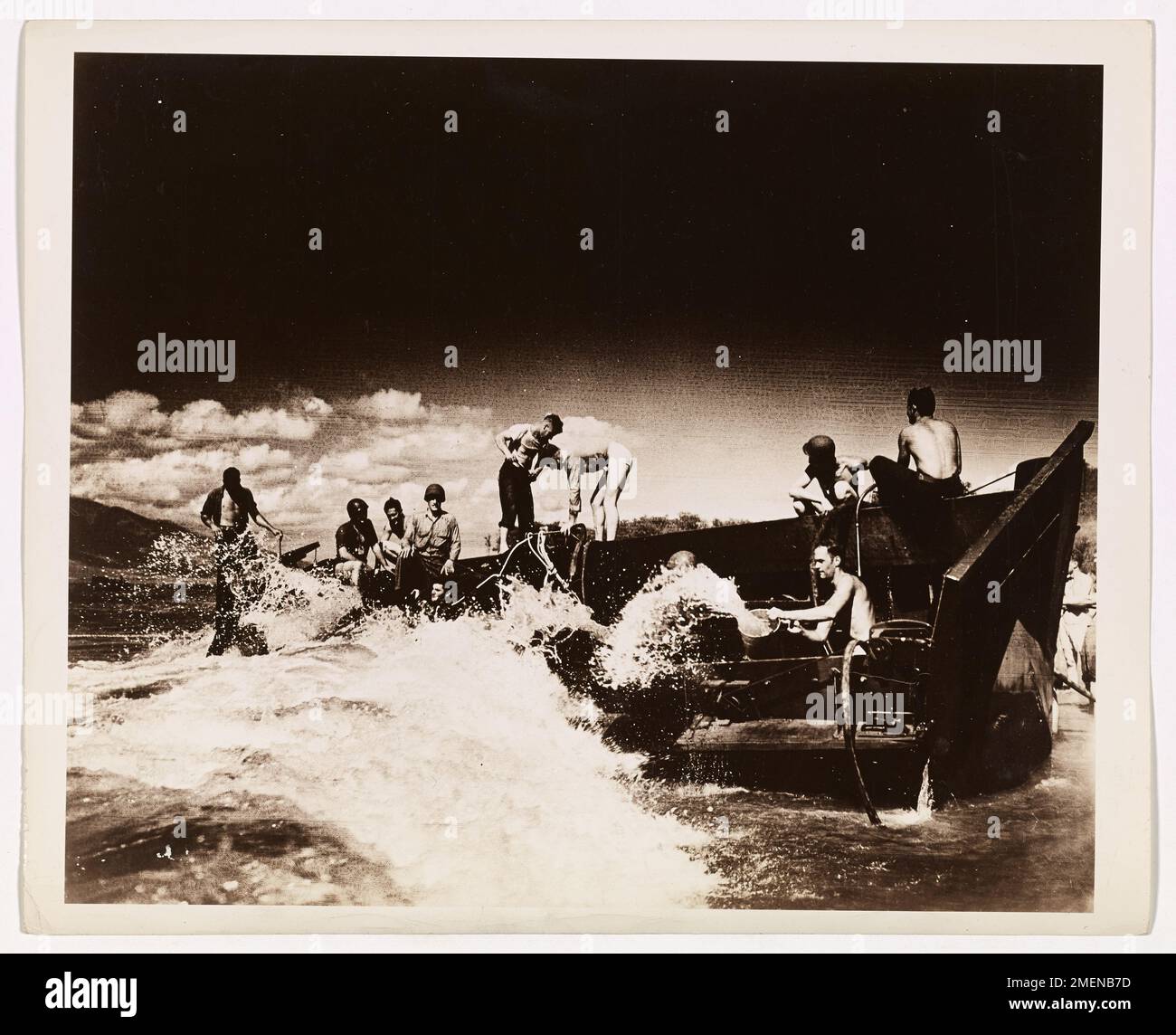 Coast Guardsmen are shown bailing out a swamped landing craft during ...