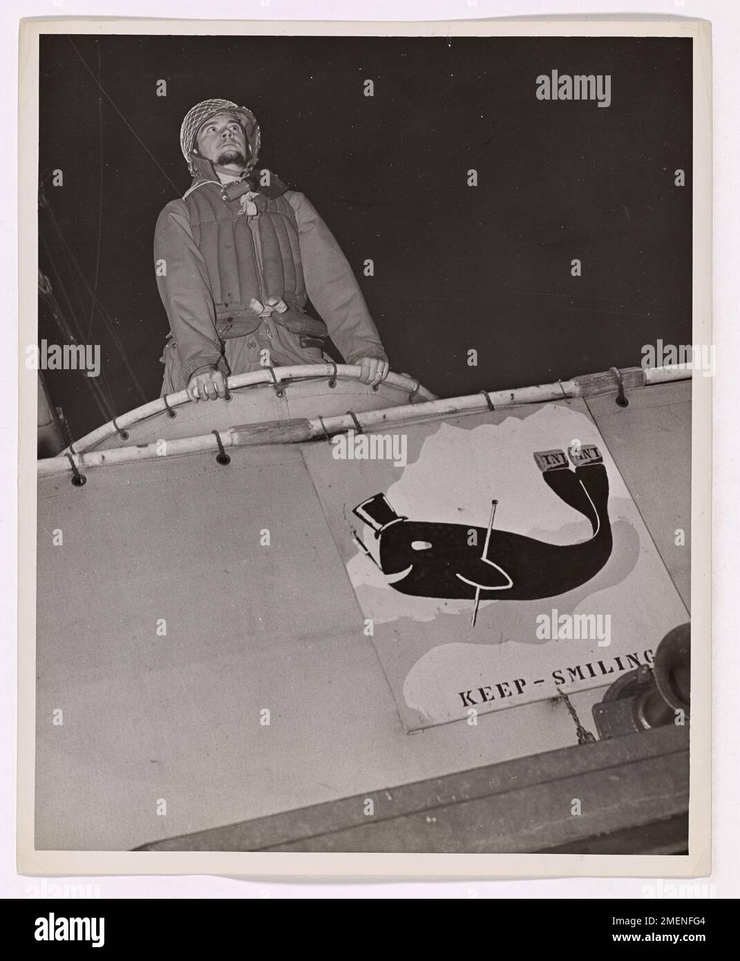 A Coast Guardsman stands vigilant on the ship's flying bridge ...