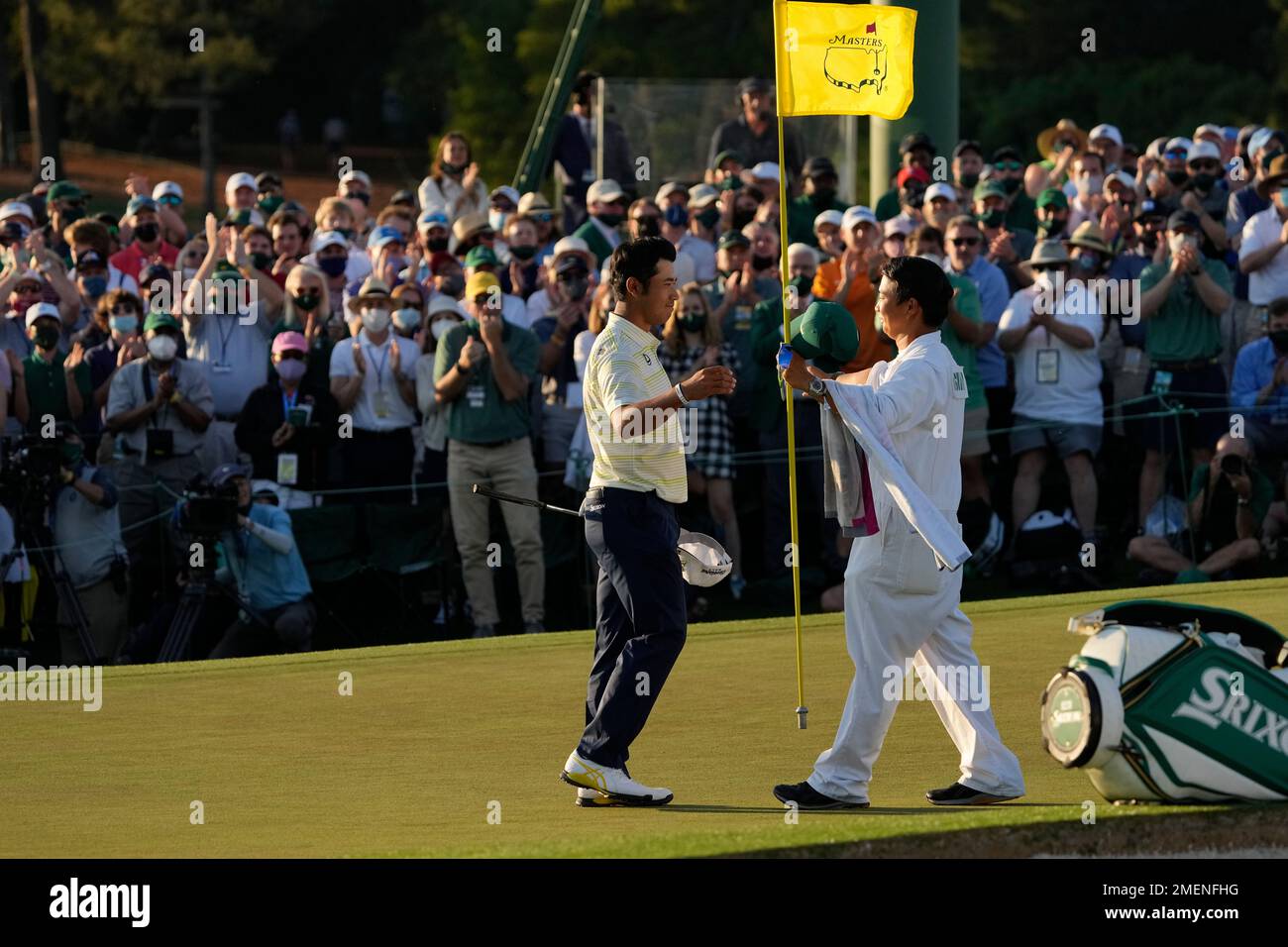 Hideki Matsuyama, of Japan, hugs his caddie Shota Hayafuji after ...