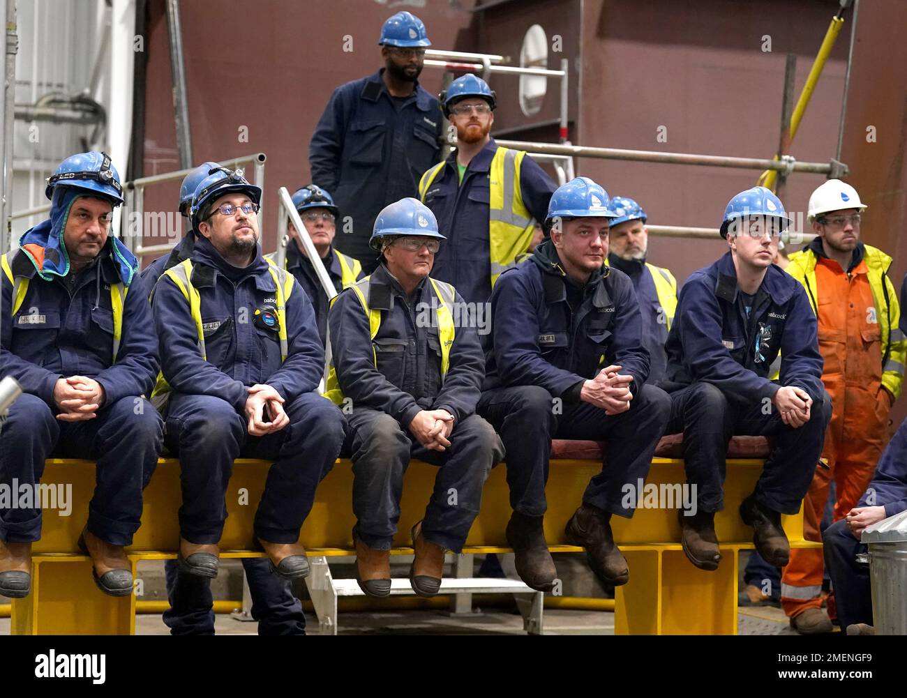 Workers look on as the first cut of steel for the Royal Navy frigate ...