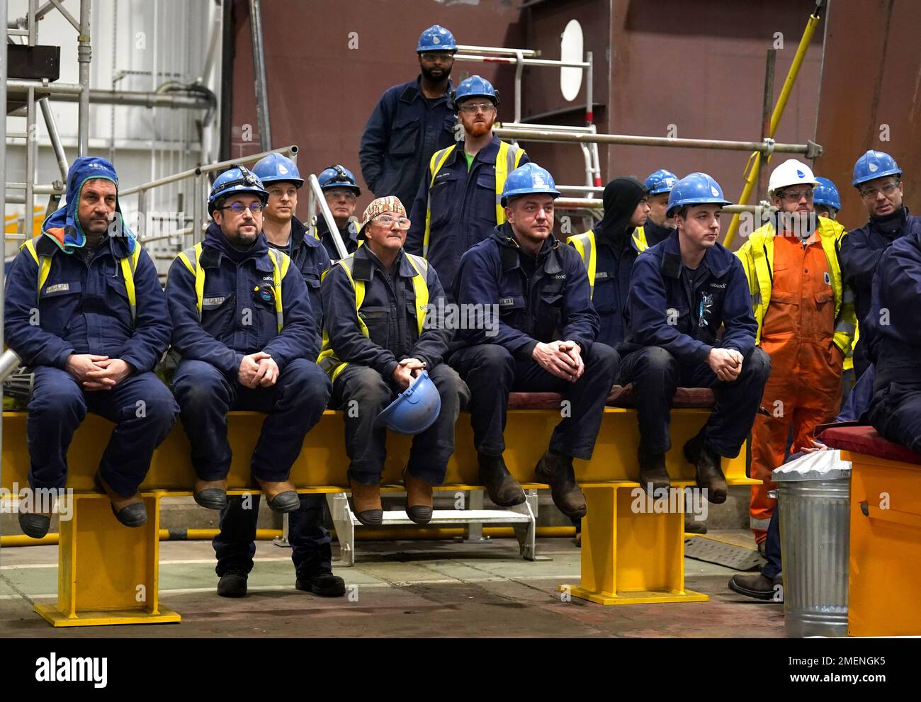 Workers look on as the first cut of steel for the Royal Navy frigate ...