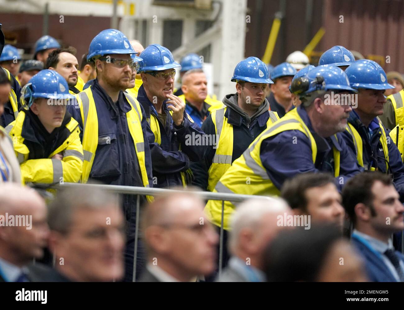 Workers look on as the first cut of steel for the Royal Navy frigate ...