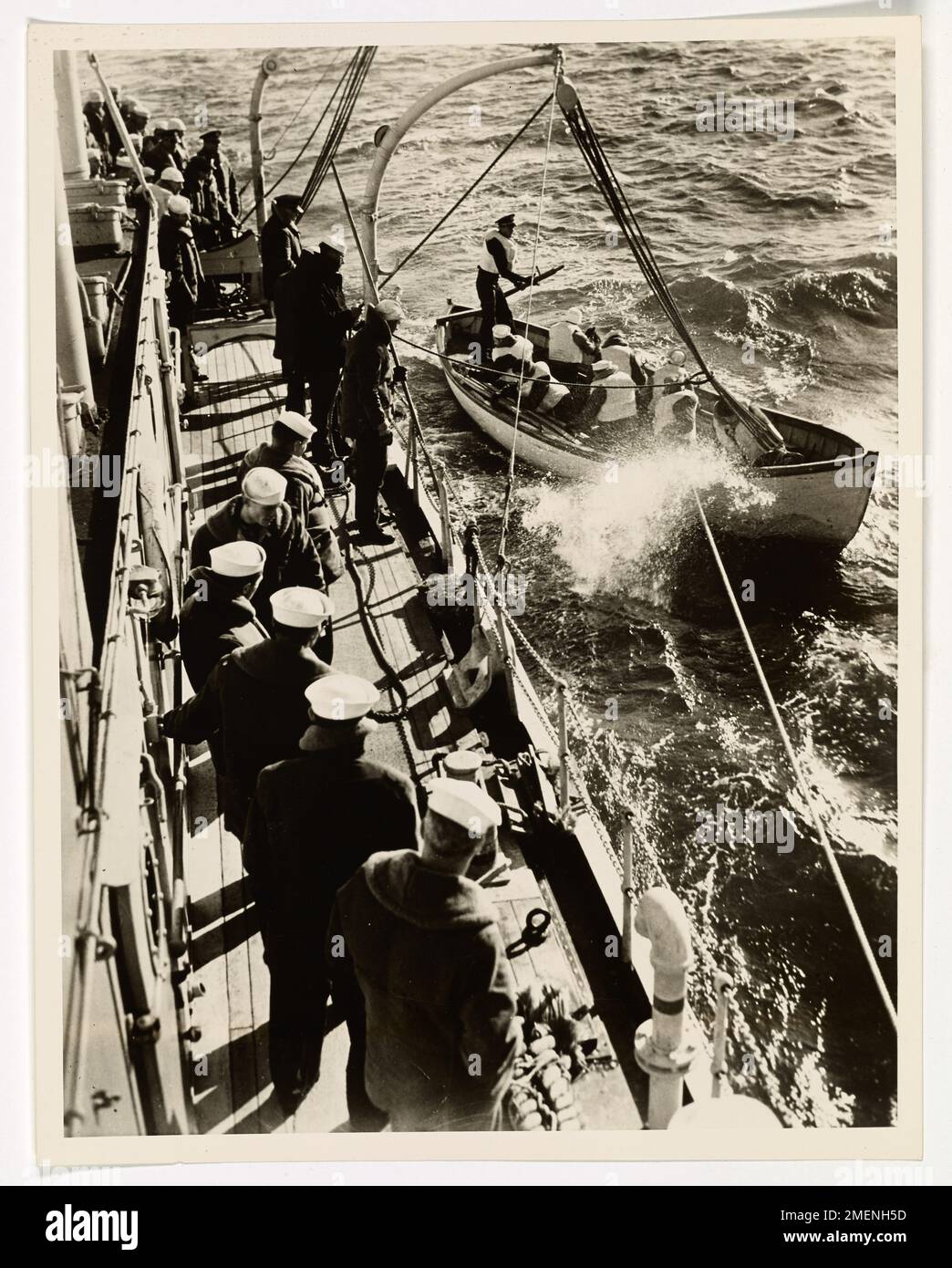 Coast Guardsmen aboard a ship conduct a boat drill, practicing ...