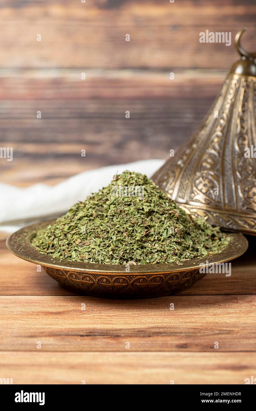 Dried mint spice. Dried mint leaves in bowl on rustic table. Dry spice ...