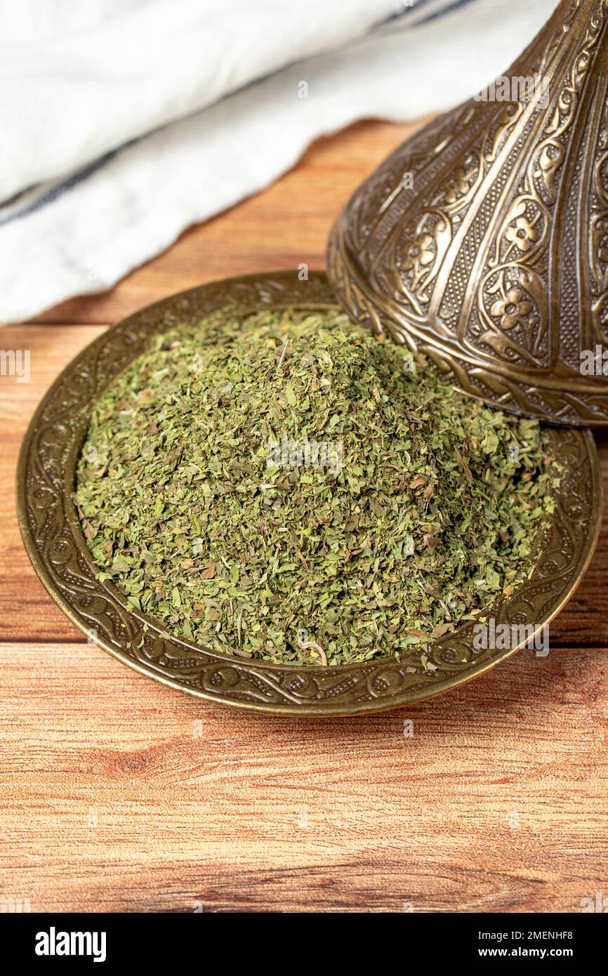 Dried mint spice. Dried mint leaves in bowl on rustic table. Dry spice ...