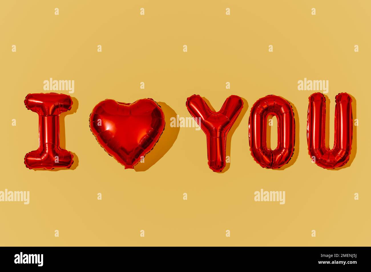 a red heart-shaped balloon and some letter-shaped balloons forming the ...