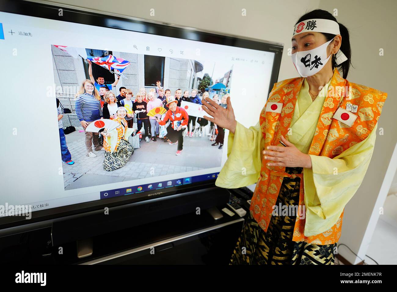 Olympic fan Kyoko Ishikawa shows an image on a TV screen showing her at ...