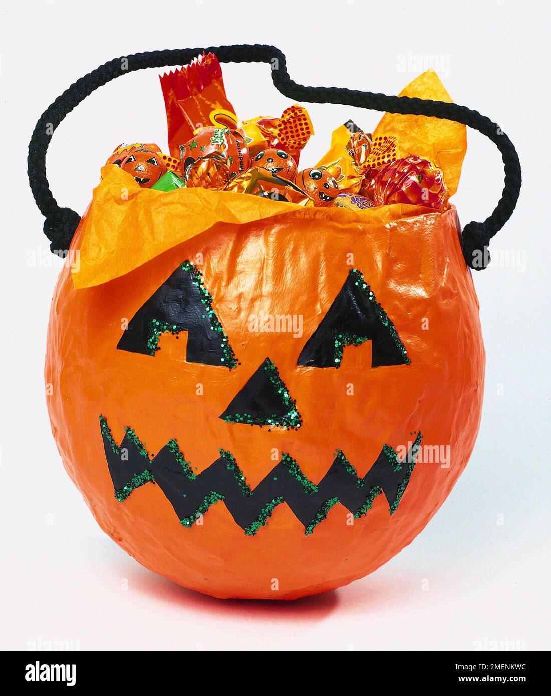 A bucket shaped like a pumpkin, full of sweets Stock Photo - Alamy