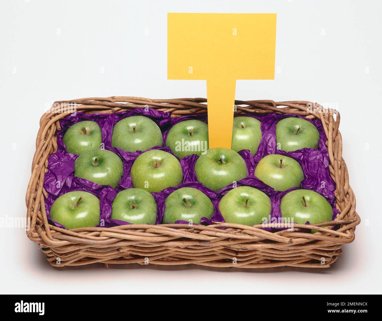 A basket of apples with a yellow price tag placed in the centre of the ...