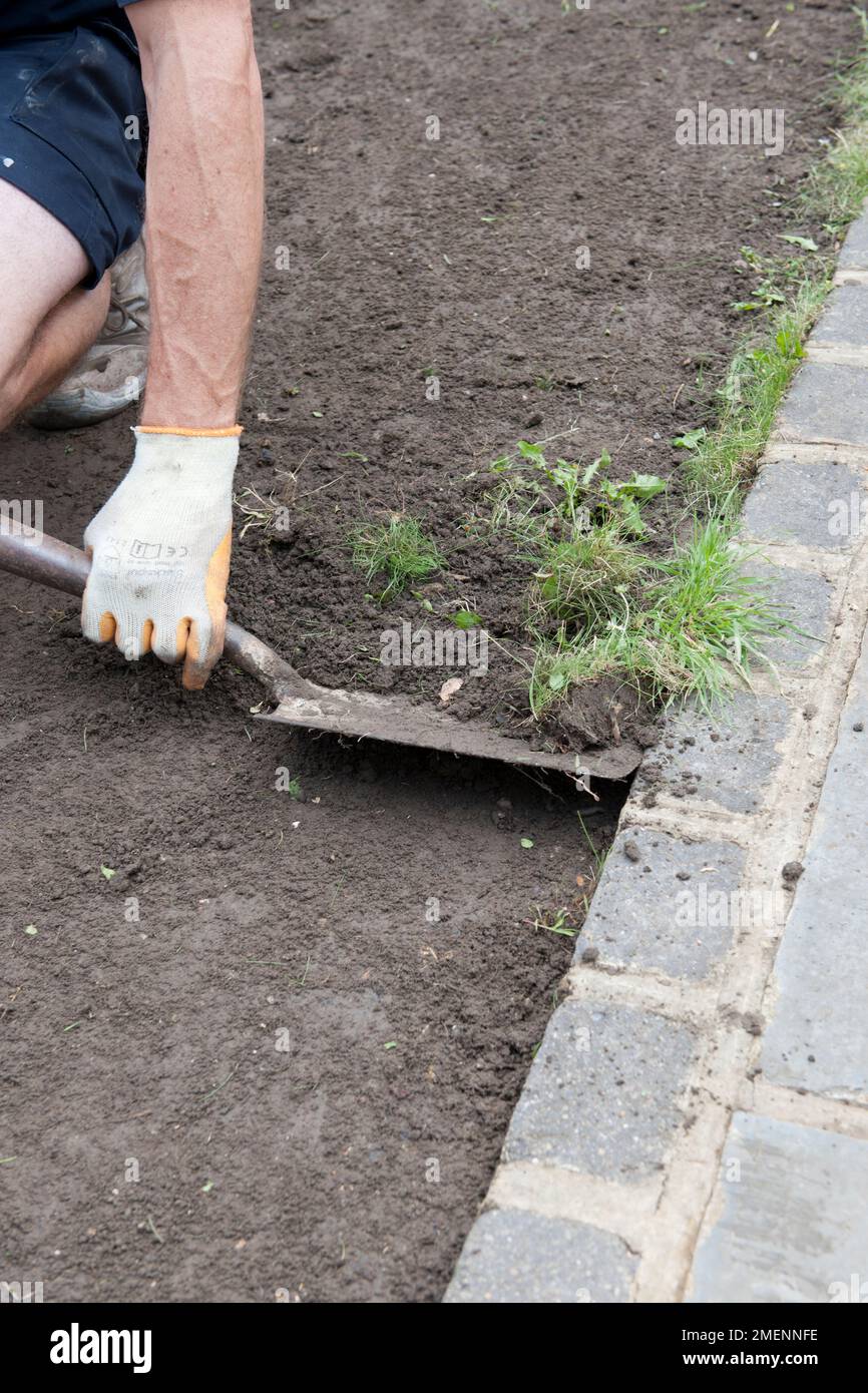 Using a spade to remove remaining patches of grass from cleared area ...