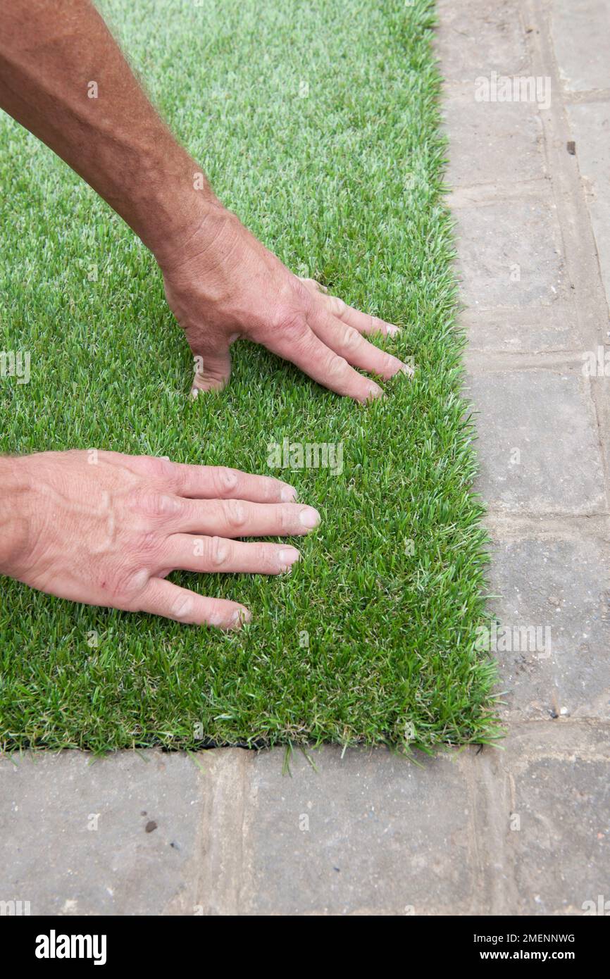 Aligning artificial turf with the corner of paving, and pushing tightly ...