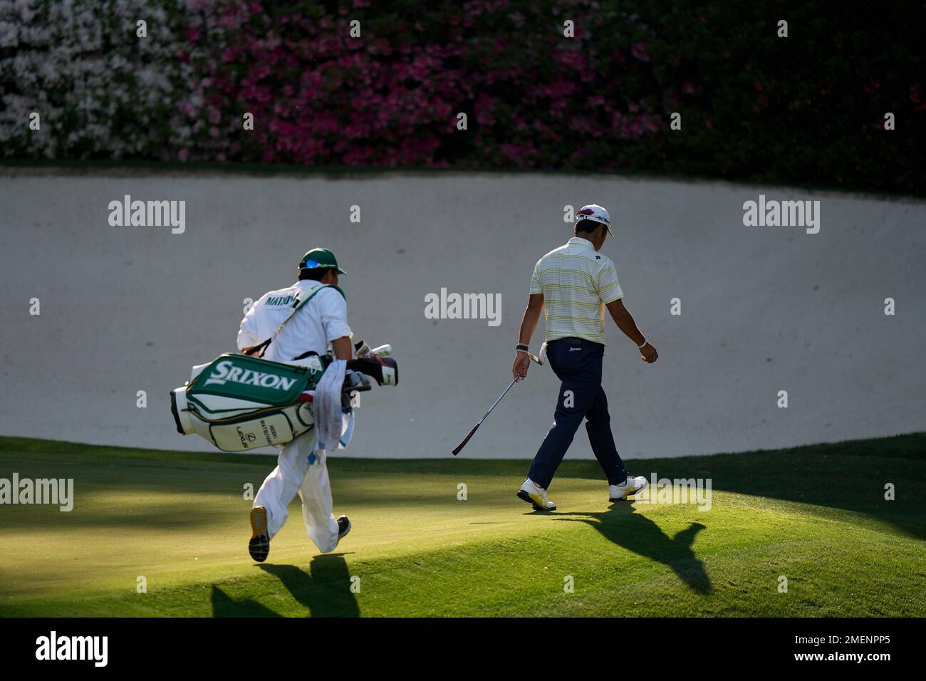 Hideki Matsuyama, of Japan, is followed by his caddie Shota Hayafuji as ...